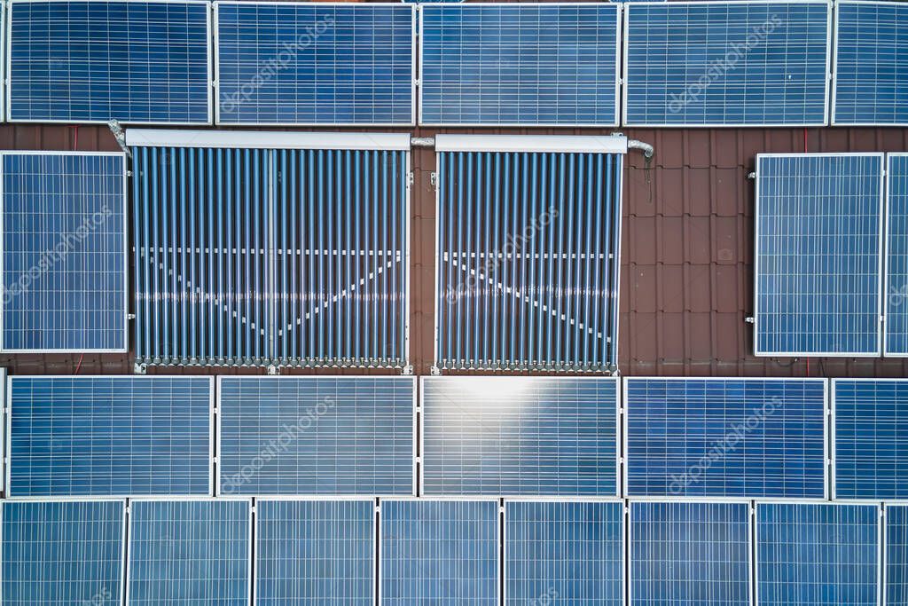 Techo de construcción con filas de paneles fotovoltaicos azules y ...