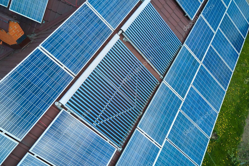 Techo de construcción con filas de paneles fotovoltaicos azules y ...