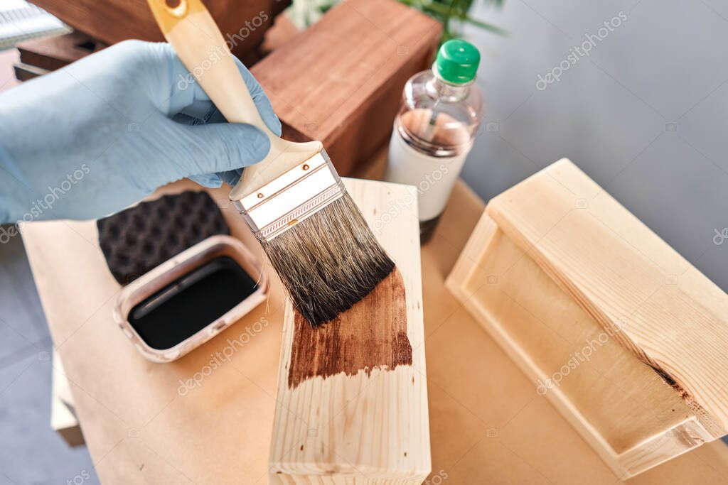 Hombre carpintero barnizado caja de madera para flores con pincel en su ...