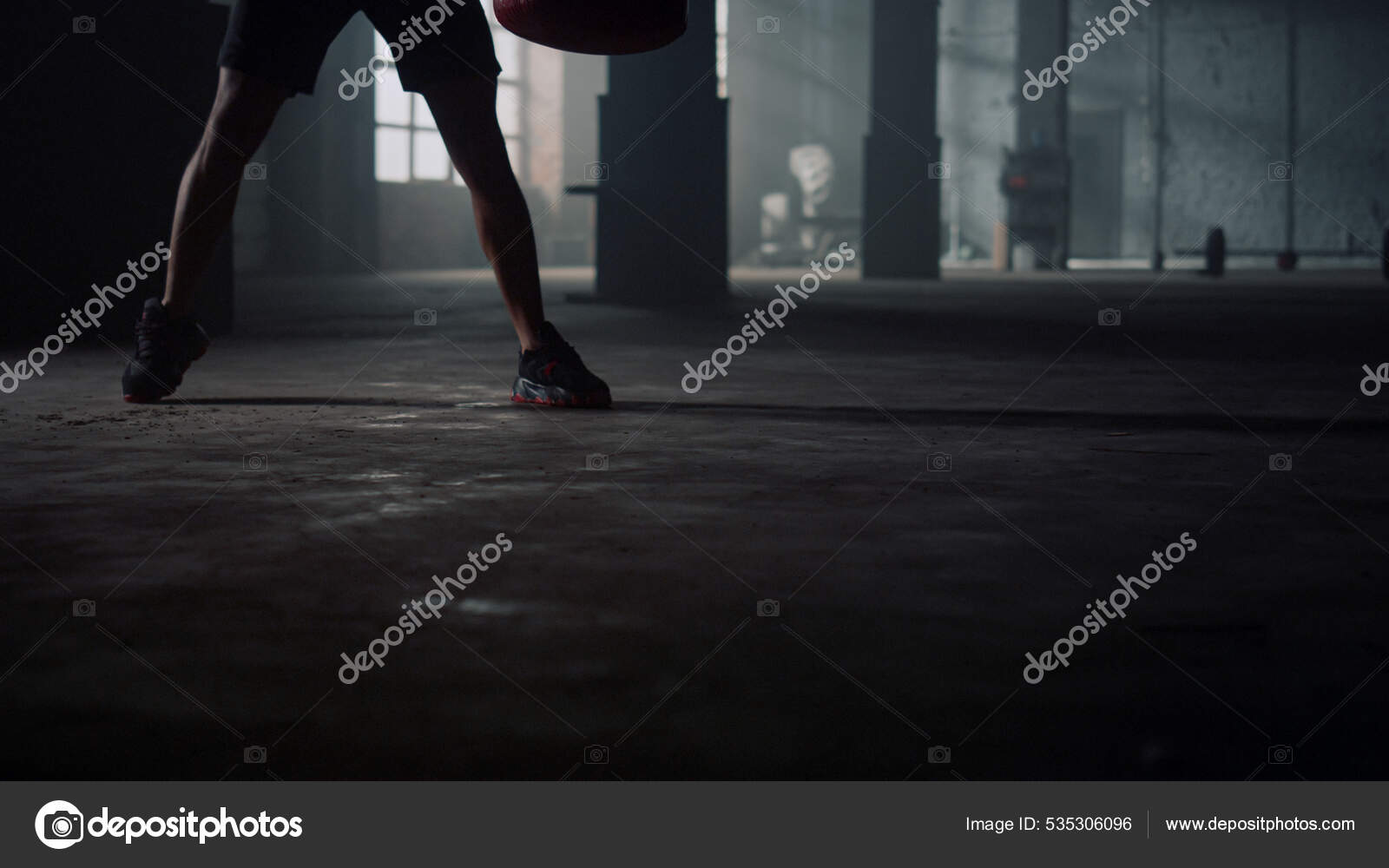 Man practicing kicks during box workout. Angry sportsman punching bag ...