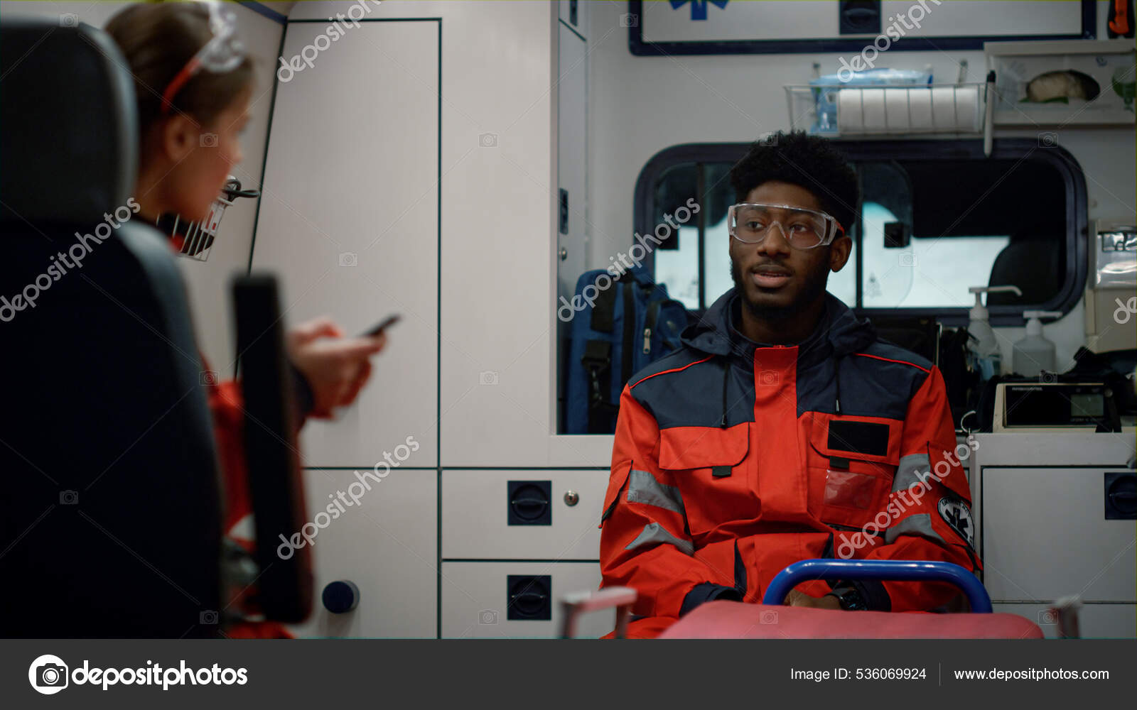 Emergency care assistants driving in ambulance car for traffic accident ...