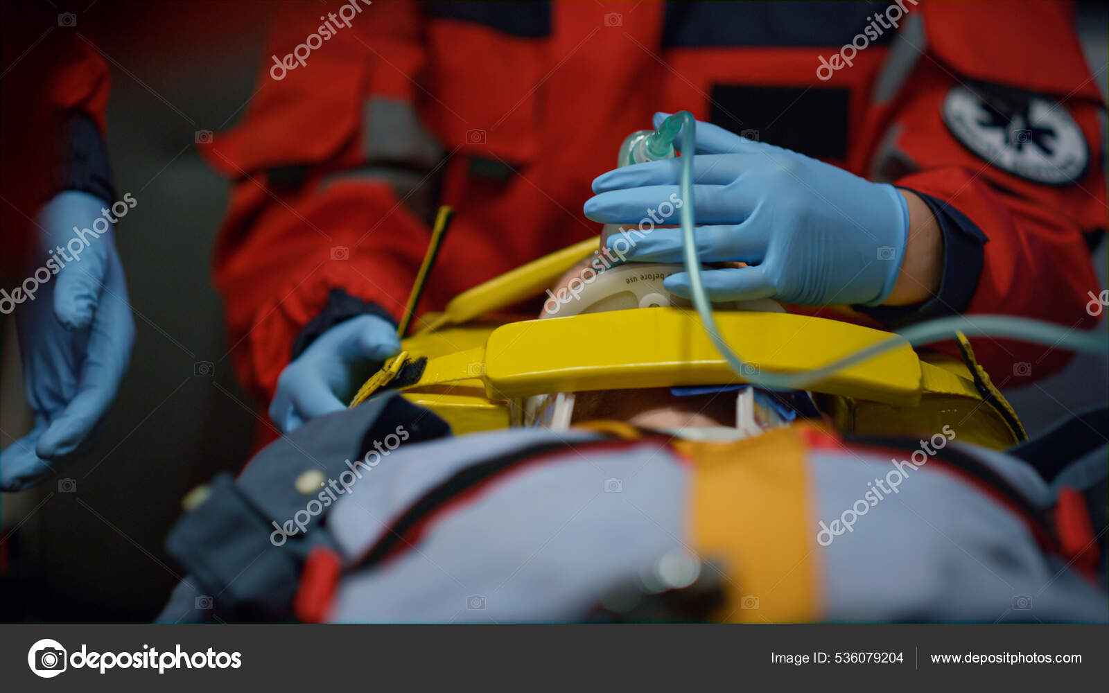 Team of paramedics providing first aid help for injured patient in ...
