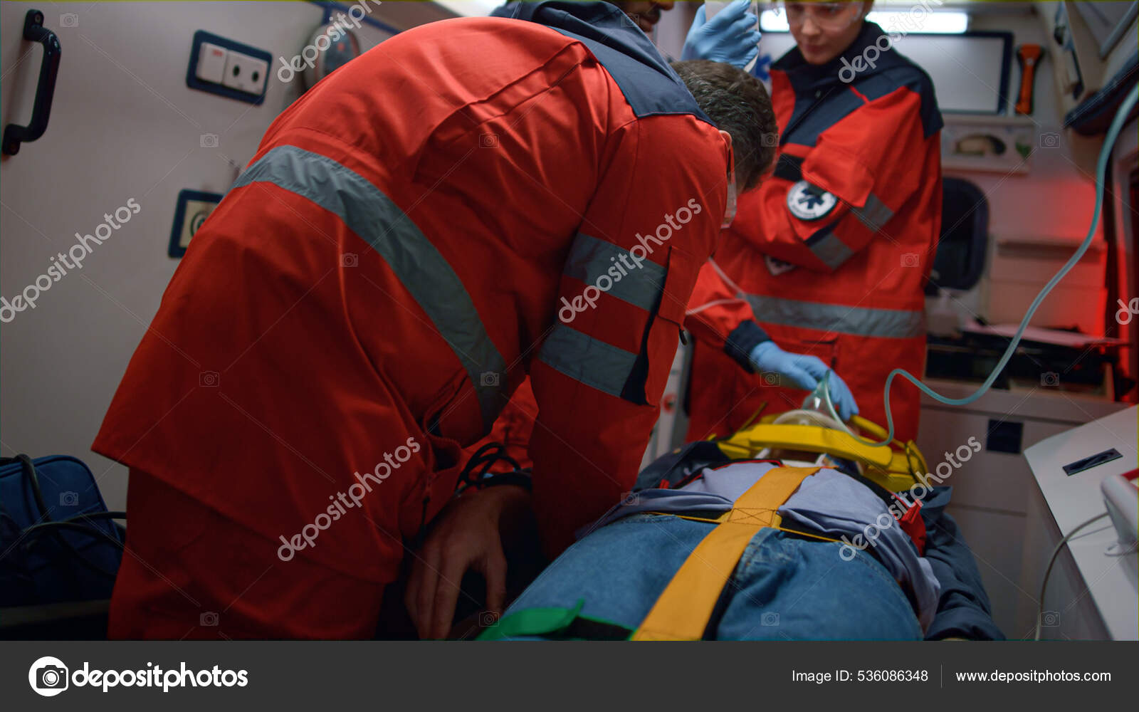 Paramedics rescuing patient in ambulance. Medical team providing first ...