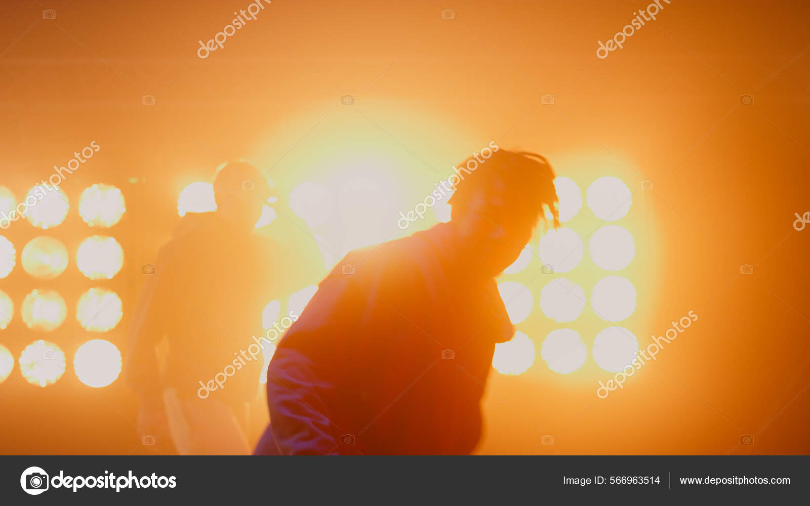 Dancing men silhouettes performing hip hop in bright spotlights club ...
