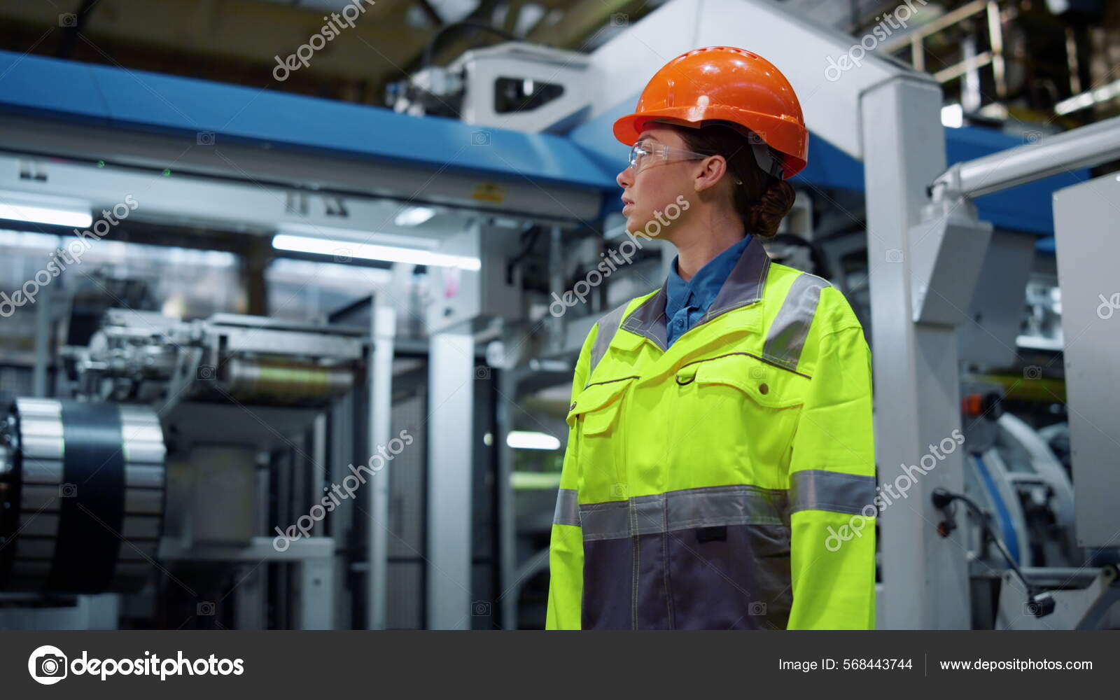 Attractive engineer look camera on manufacturing modern factory. Plant ...