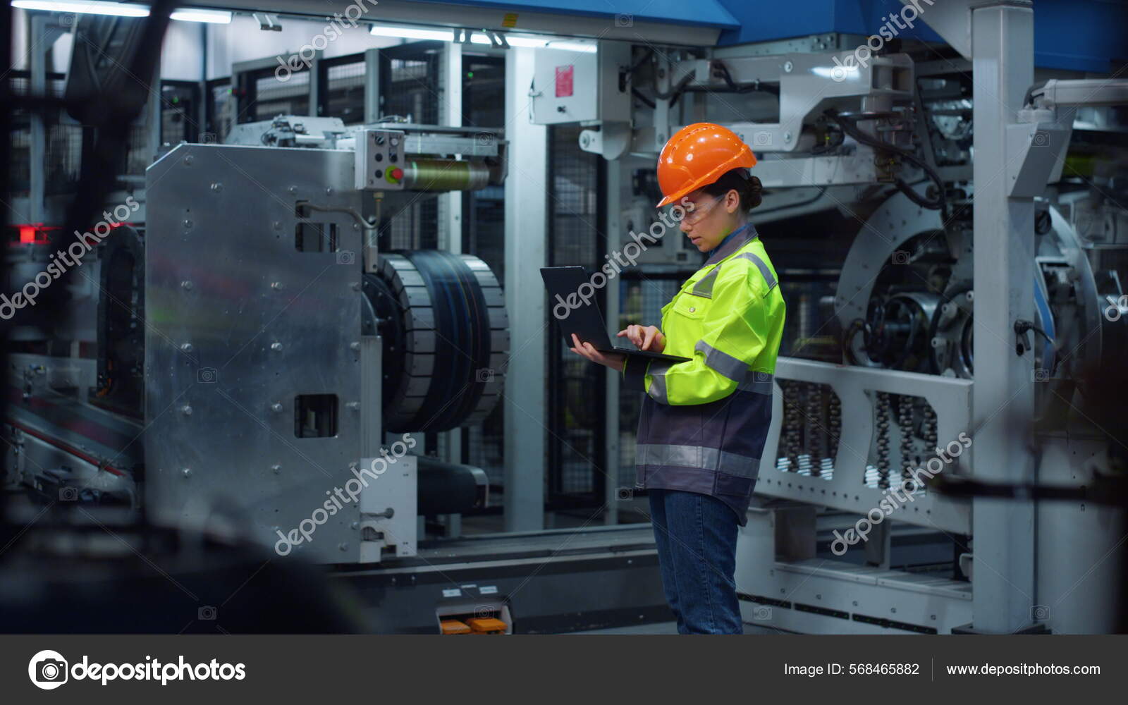 Engineer typing laptop computer wearing safety uniform on modern ...