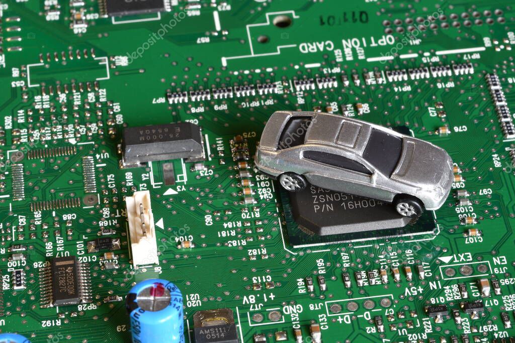 Coches de juguete en tablero electrónico y microchip. La escasez de microchips y semiconductores ...