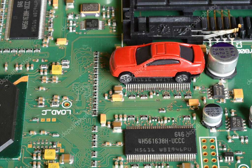 Coches de juguete en tablero electrónico y microchip. La escasez de microchips y semiconductores ...