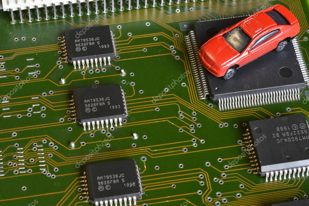 Coches de juguete en tablero electrónico y microchip. La escasez de microchips y semiconductores ...