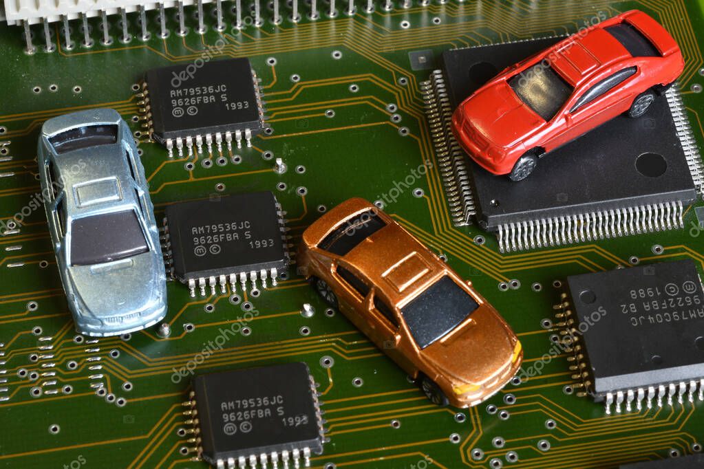 Coches de juguete en tablero electrónico y microchip. La escasez de microchips y semiconductores ...