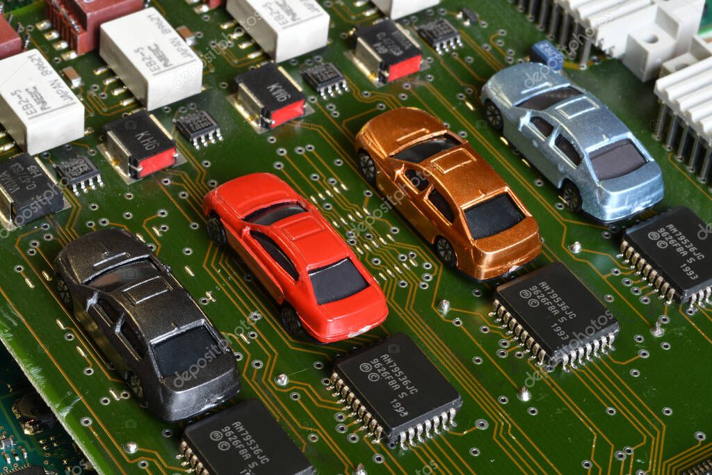 Coches de juguete en tablero electrónico y microchip. La escasez de microchips y semiconductores ...