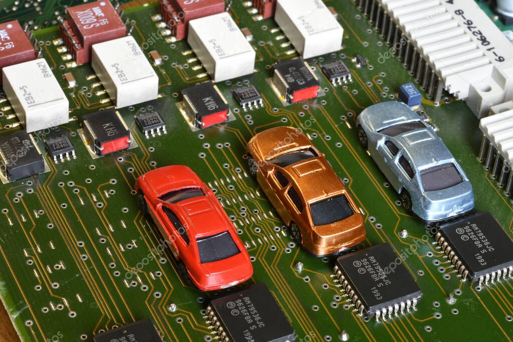 Coches de juguete en tablero electrónico y microchip. La escasez de microchips y semiconductores ...
