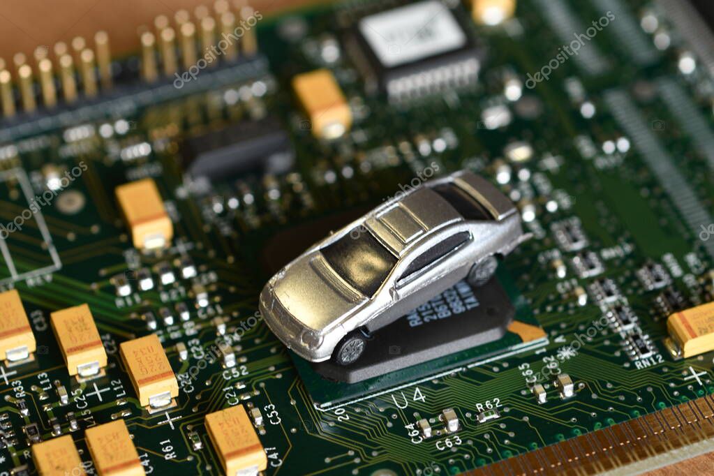 Coches de juguete en tablero electrónico y microchip. La escasez de microchips y semiconductores ...