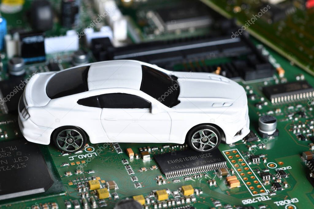 Coche de juguete en tablero electrónico y microchip. Imagen conceptual para la escasez de ...