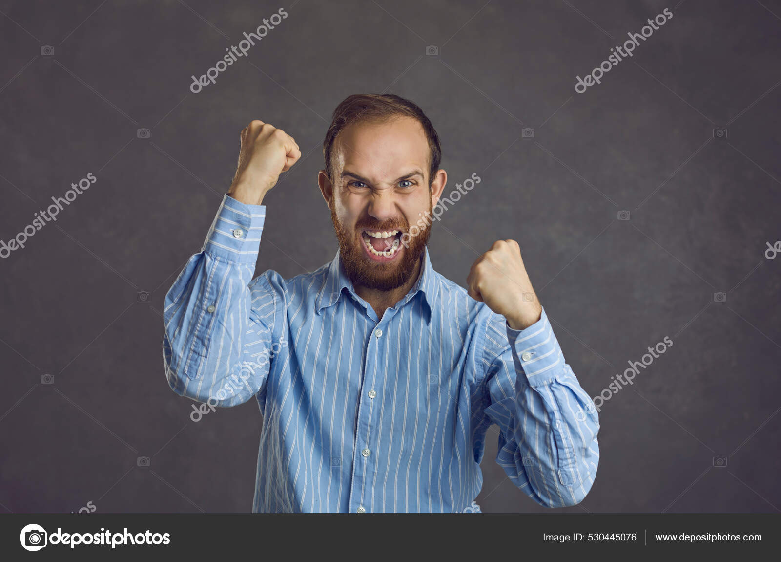 Studio portrait of angry aggressive frustrated man clenching fists and ...