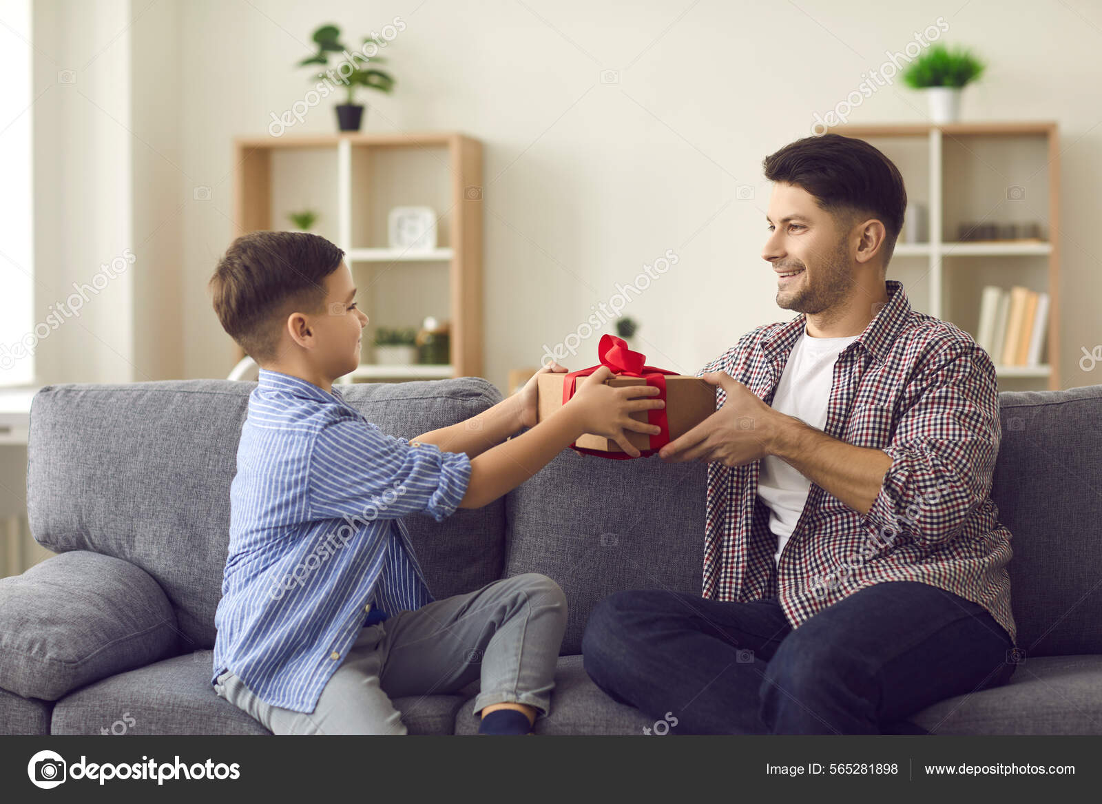 Cute boy gives congratulations to his dad on the holiday and gives him ...