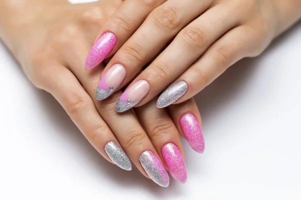 Shiny manicure on sharp long nails. Gel manicure. Pink silver French ...