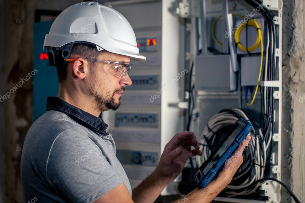 Hombre, un técnico eléctrico trabajando en una centralita con fusibles ...