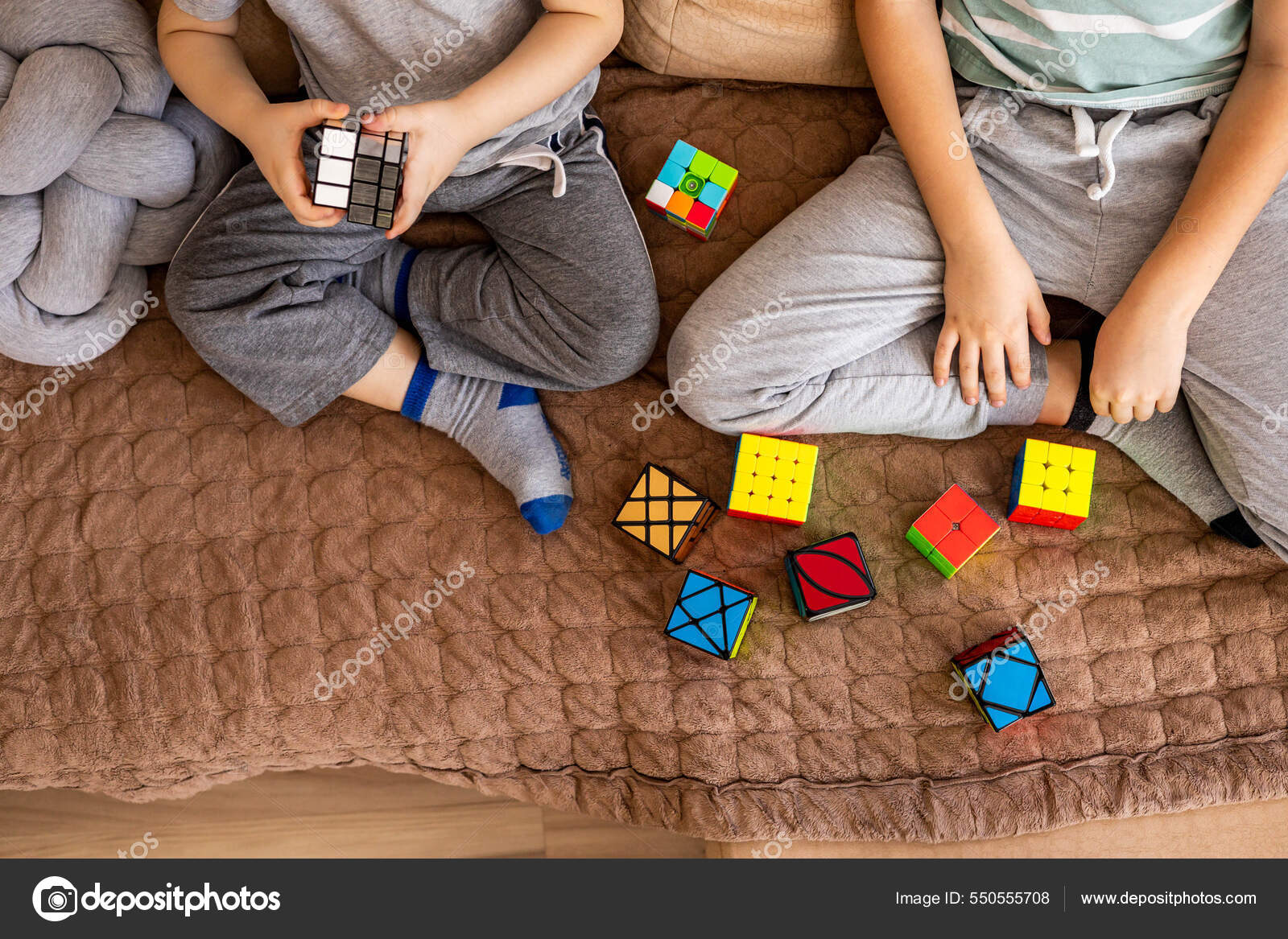 Two male kids brothers assembling Rubiks cube thinking solving logic ...