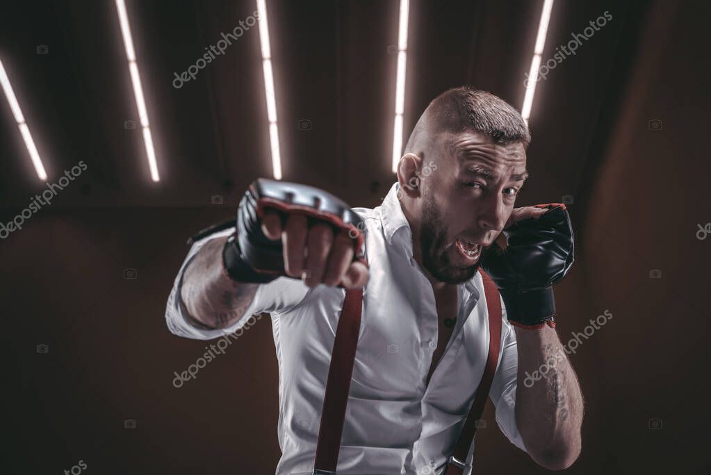 Imagen de un brutal hombre barbudo boxeando en almohadillas deportivas ...