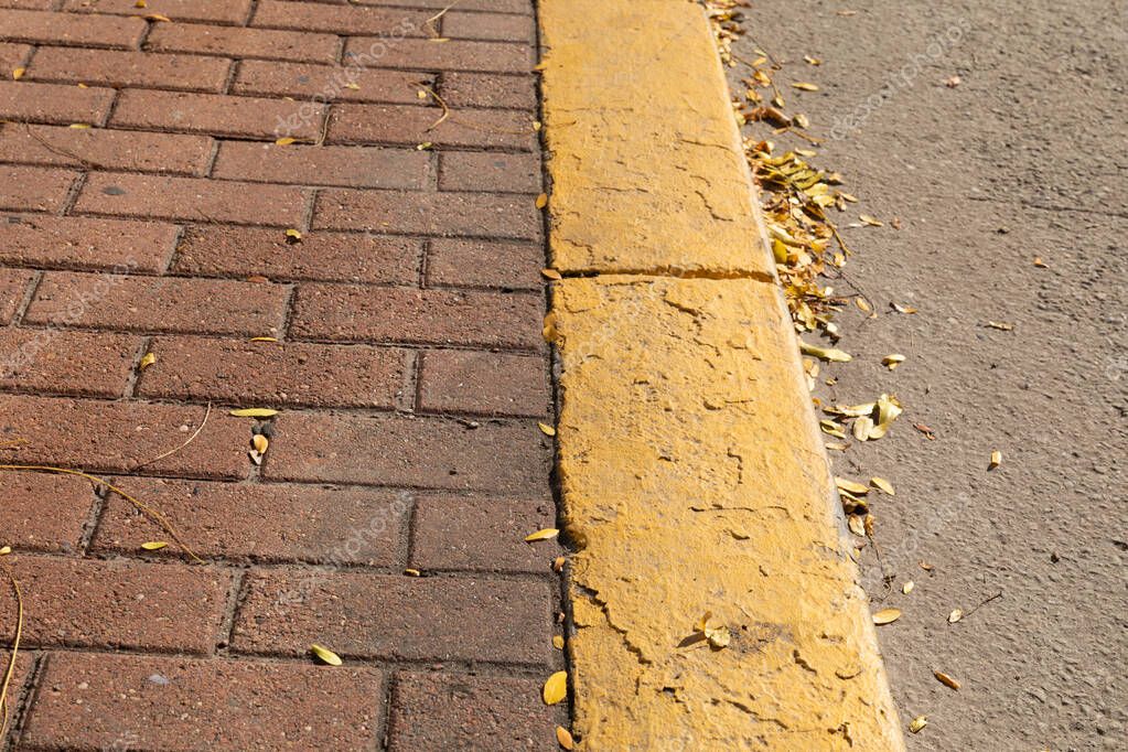 Acera de ladrillo rojo bordeada de acera de hormigón pintado de color ...