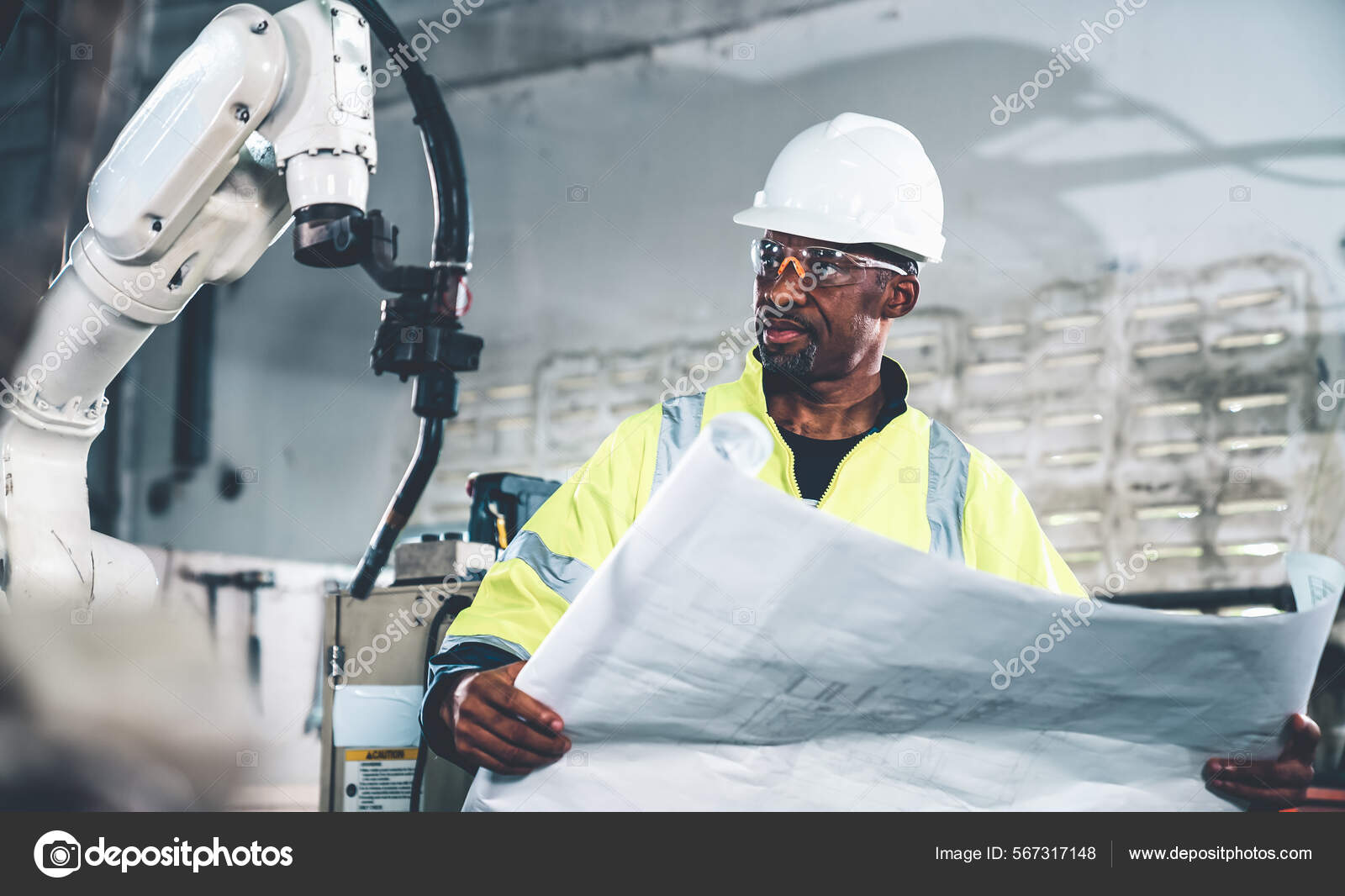 African American factory worker working with adept robotic arm Stock ...