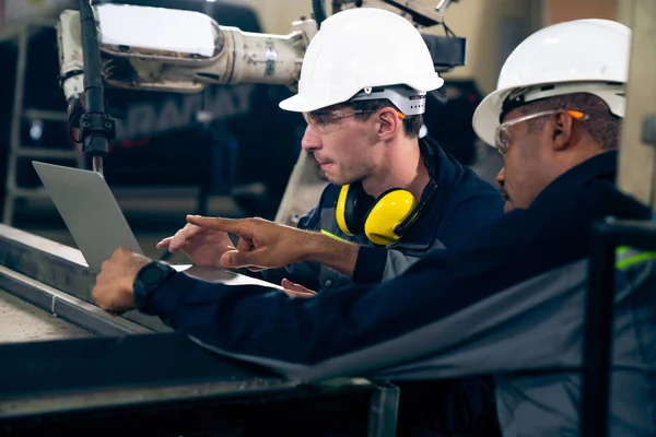 Factory workers working with adept robotic arm in a workshop . Industry ...